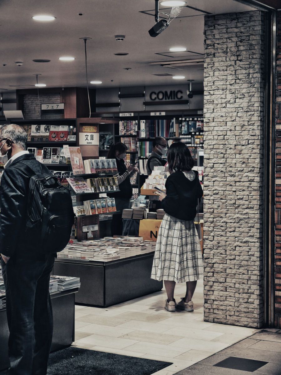 Watching smartphone at a bookstore. | GANREF