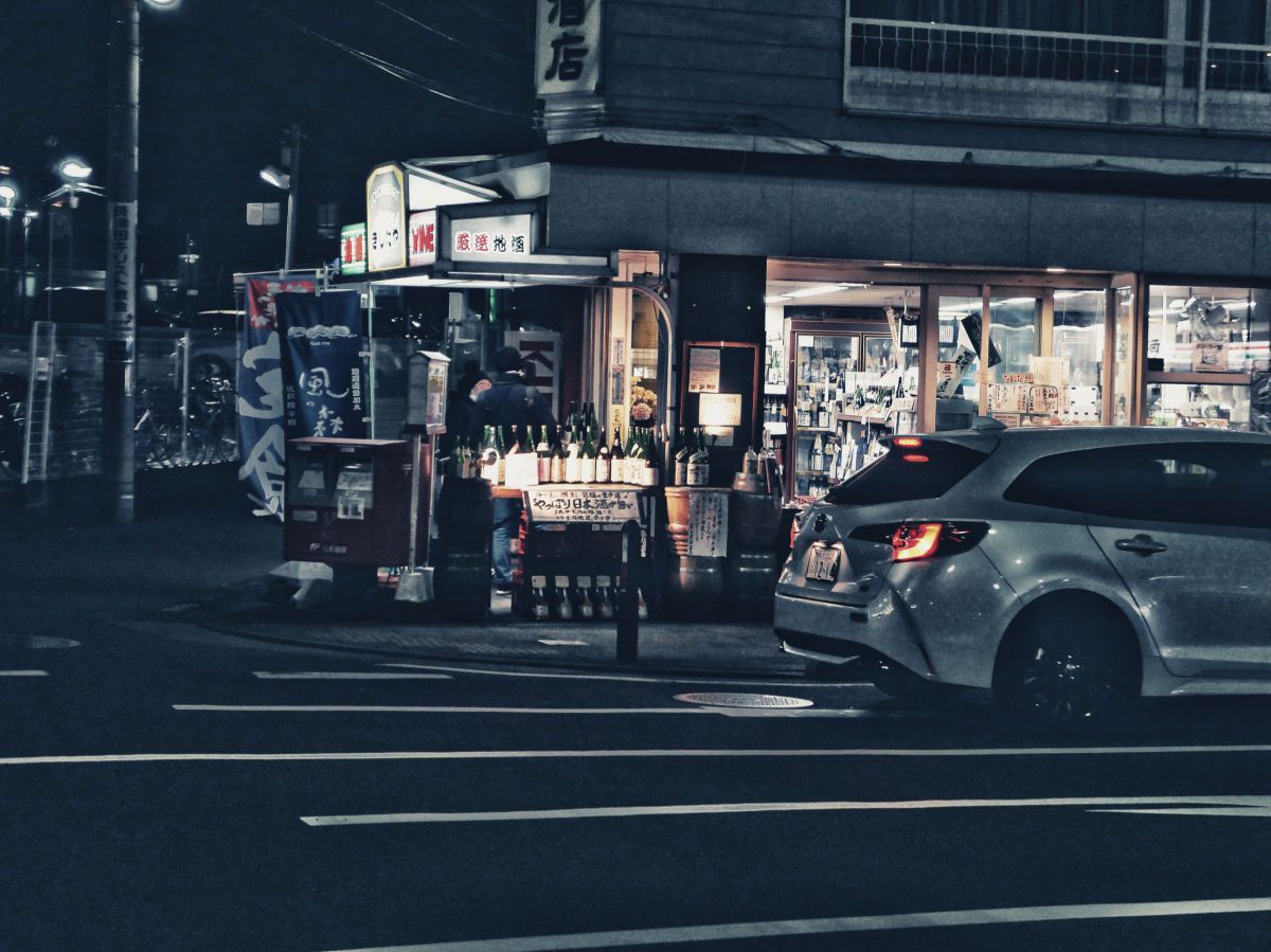 Under the eaves of a liquor shop. | GANREF