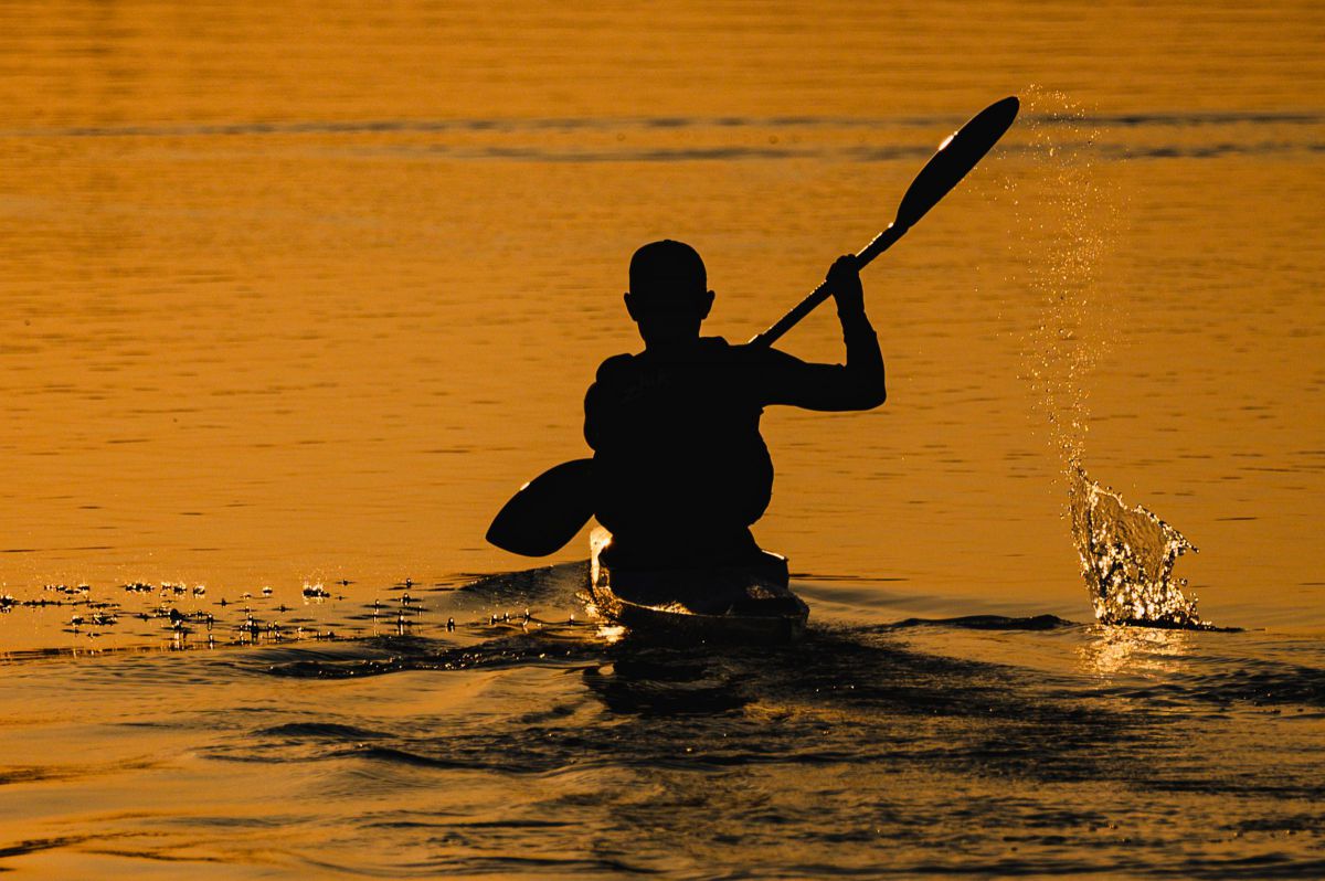 Man paddling a kayak in the morning sun | GANREF